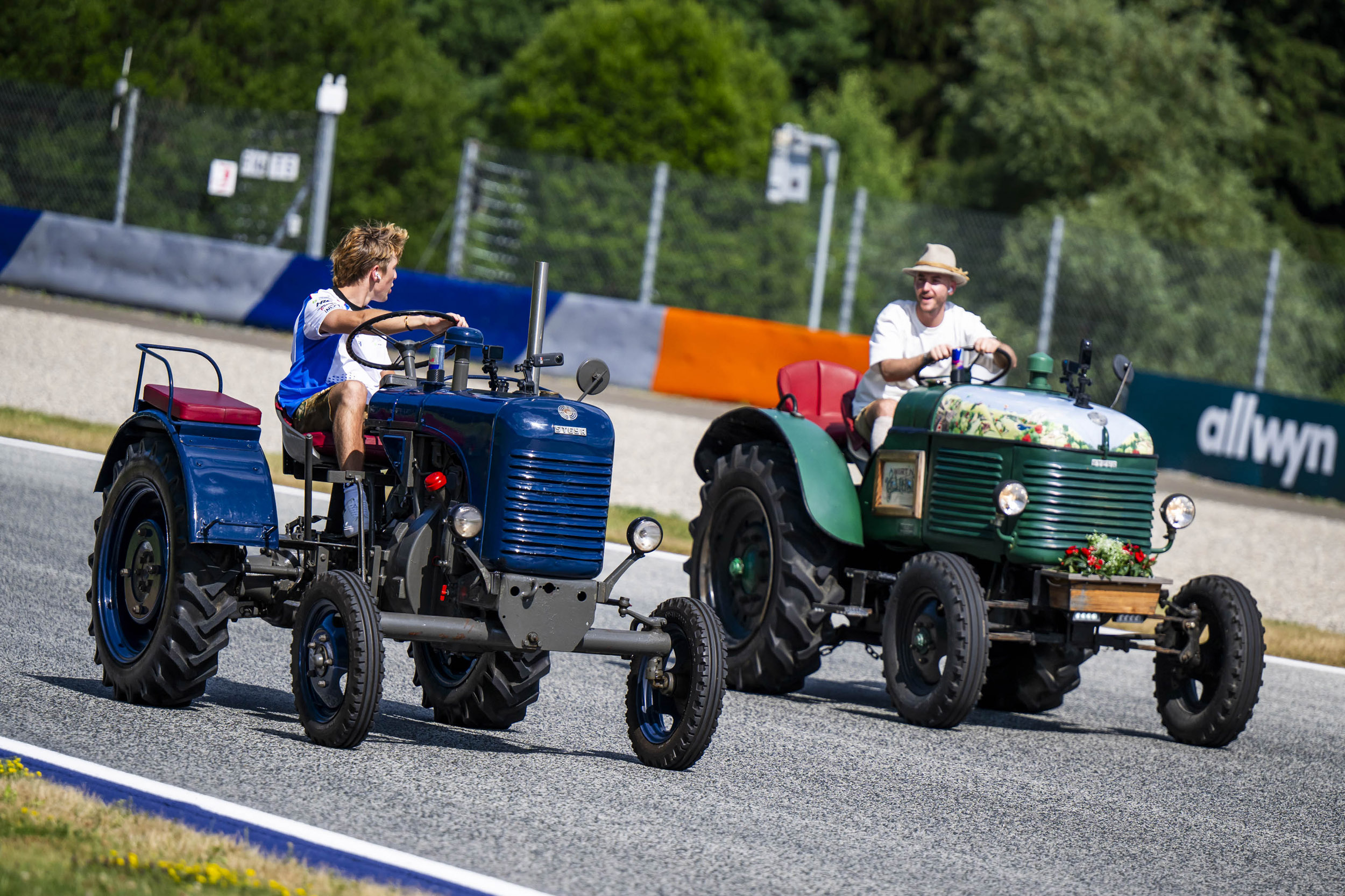 Two kiwis racing tractors on an F1 circuit