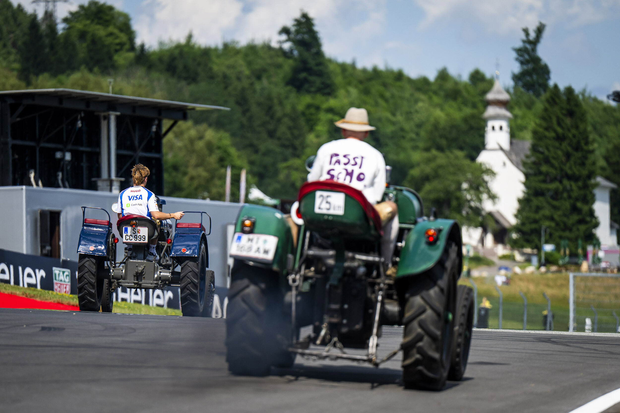 Two kiwis racing tractors on an F1 circuit