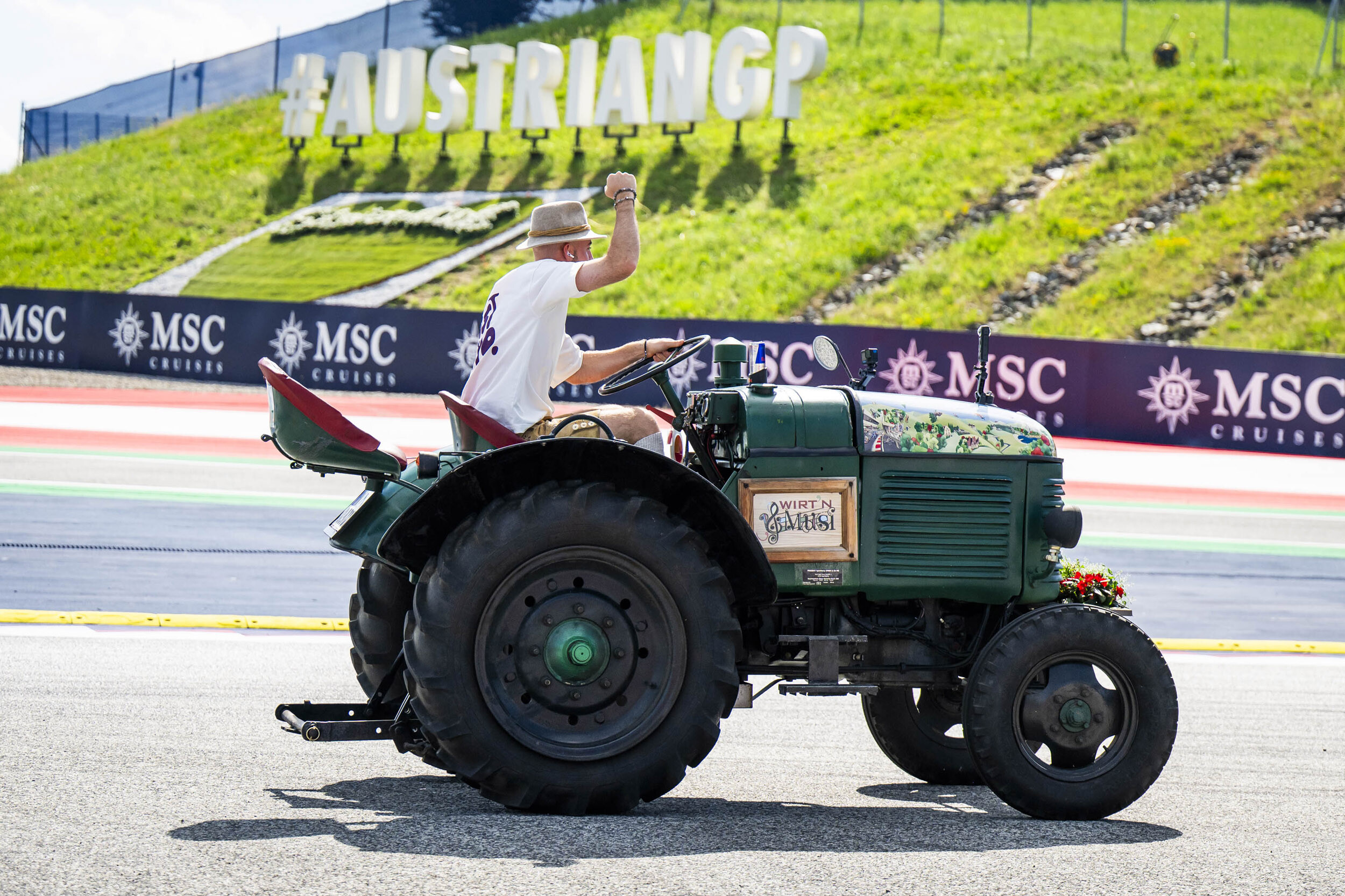 Two kiwis racing tractors on an F1 circuit